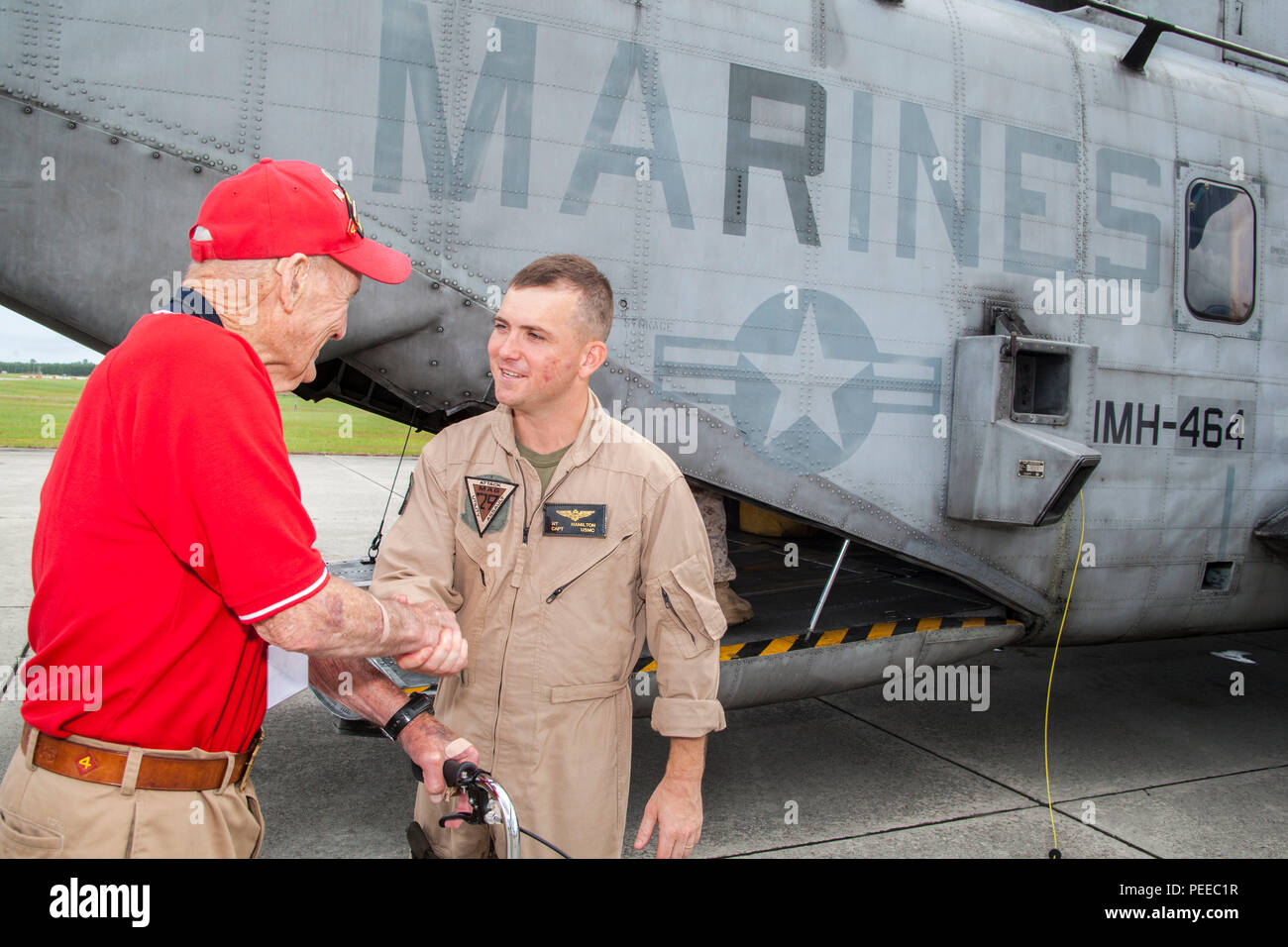 A veteran shakes hands with U.S. Marine Corps Capt. Nicholas Hamilton ...