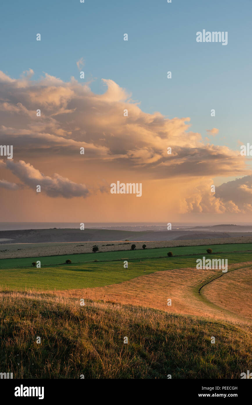 Stunning moody sunset over South Downs National Park in England stormy rain clouds out to sea in ...