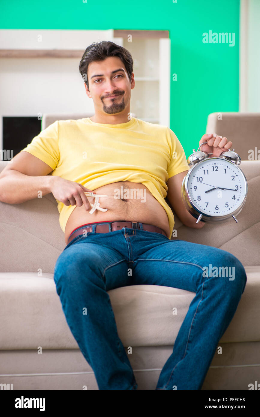 Man measuring body fat with calipers in time management concept Stock ...