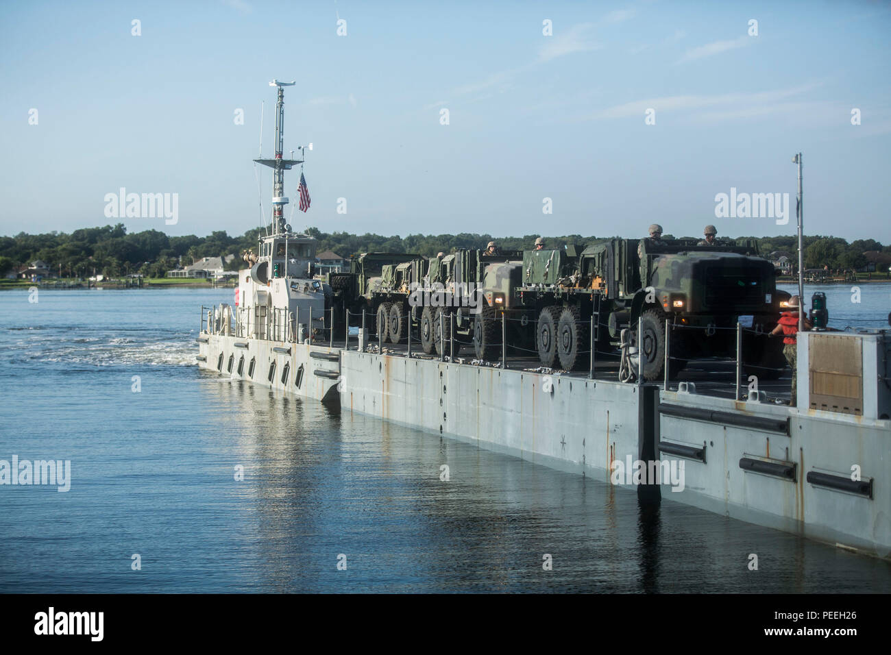 Marines load vehicles onto an Improved Navy Lighterage System and ...