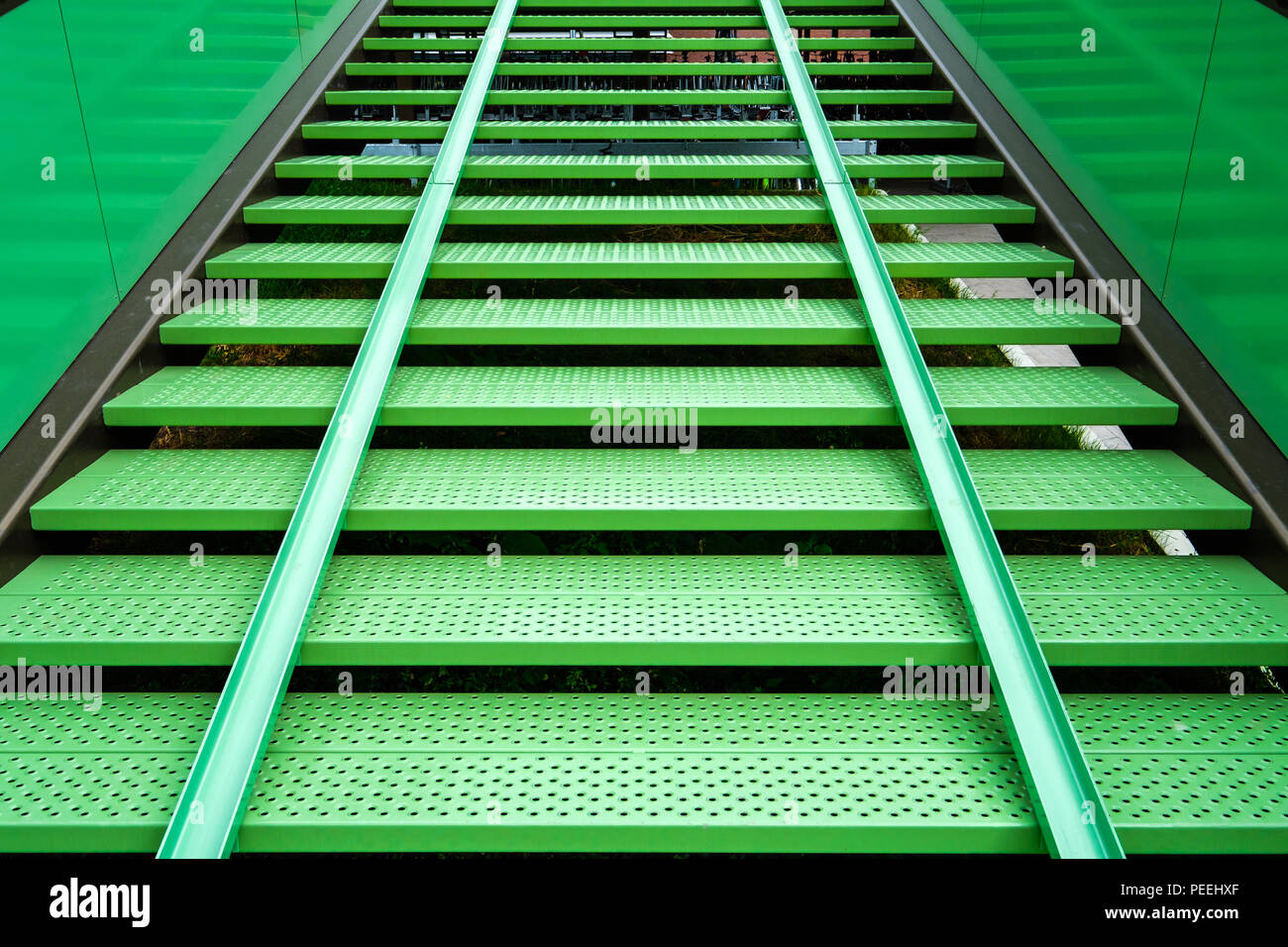 Modern green steel staircase in a bicycle parking with bicycle gutter ...