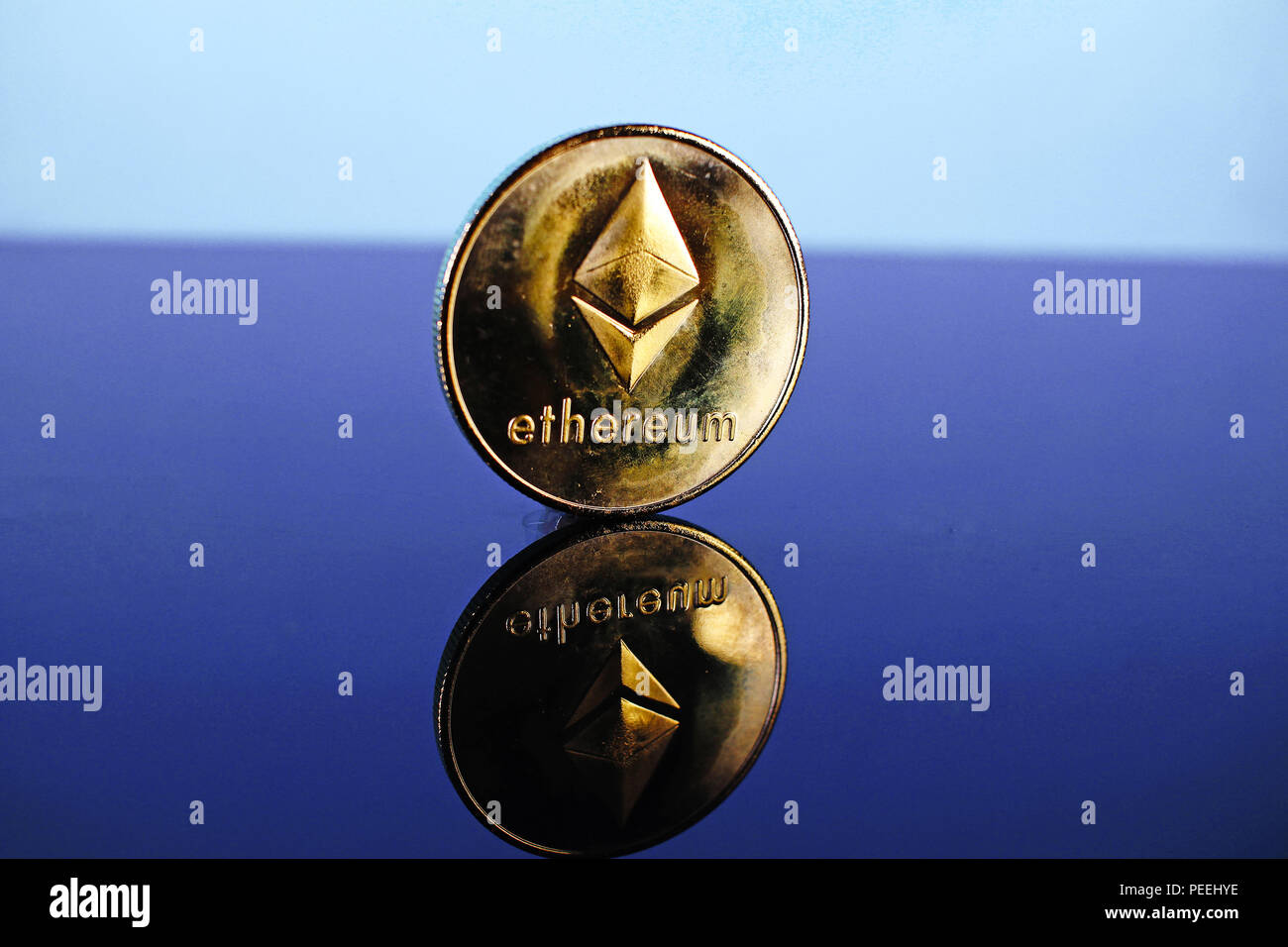 Etherum money crypto currency coin on reflective colorful background Stock Photo - Alamy