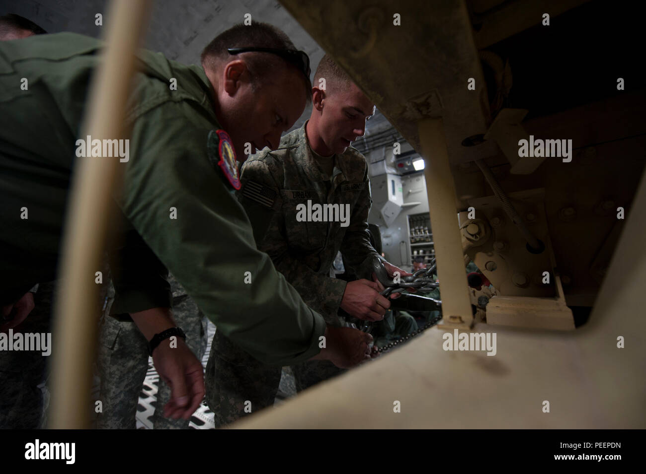 A C-17 loadmaster shows a soldier how to secure a load Aug. 4, 2015, at ...
