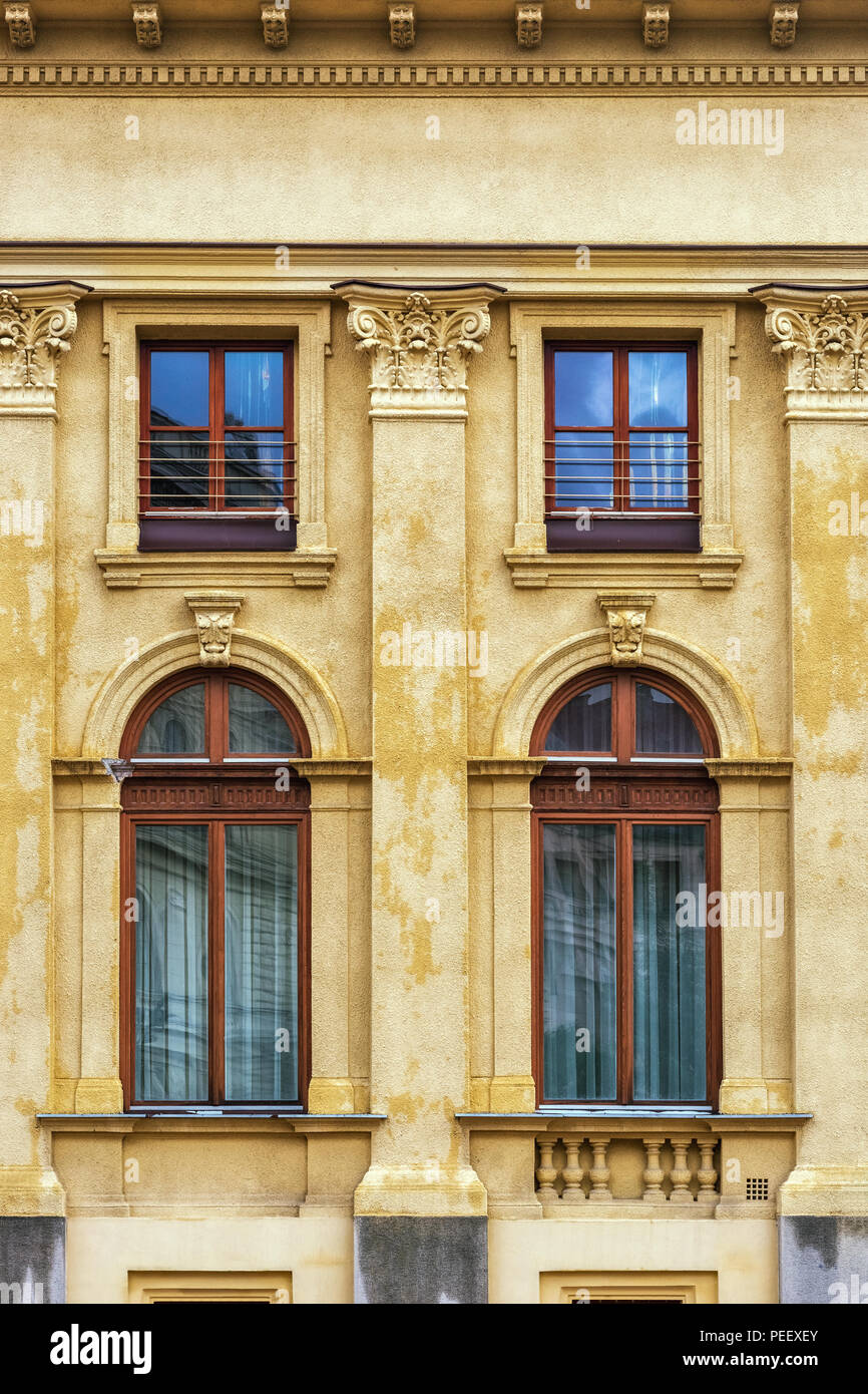 Four Windows with wooden brown frames, located on a yellow wall with ...
