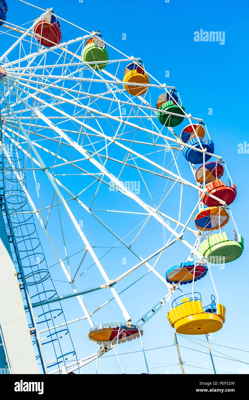 Colorful ferris wheel of the amusement park in the blue sky background ...