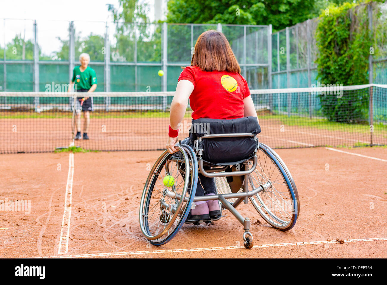 Disabled young woman on wheelchair playing tennis on tennis court Stock ...