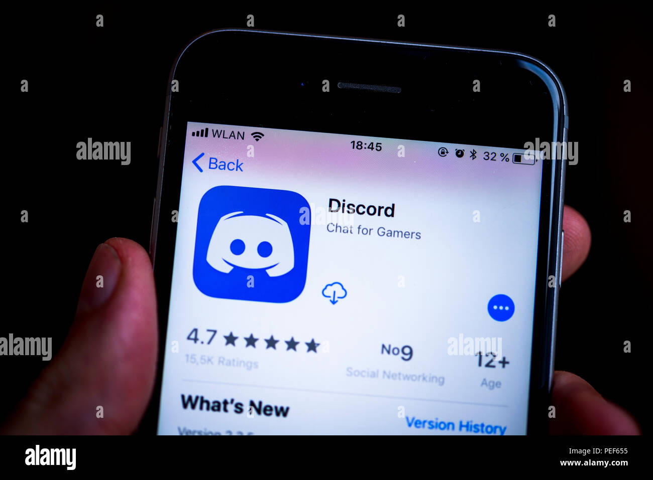 Hand holding iPhone displaying Dicord App in the Apple App Store ...