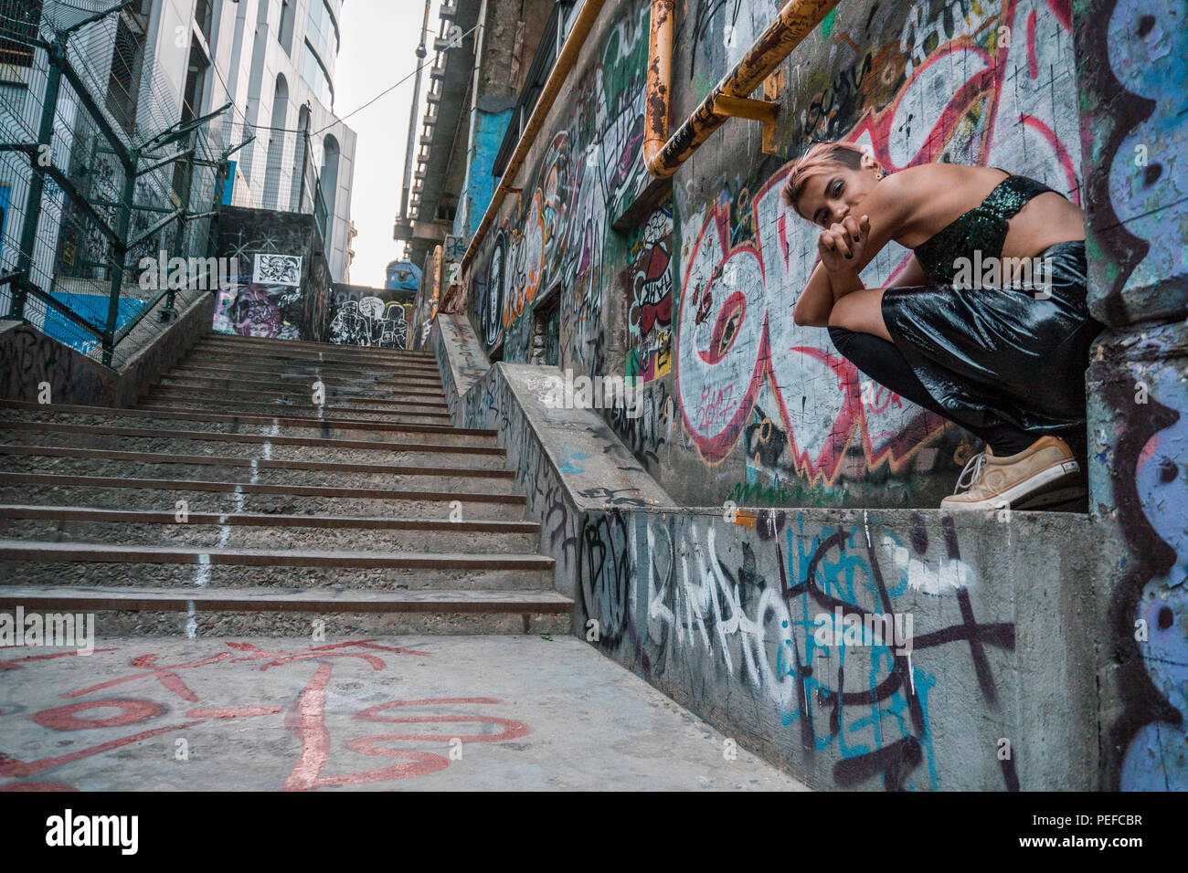 Street punk girl Sitting near the concrete stairs. Urban lifestyle in ...