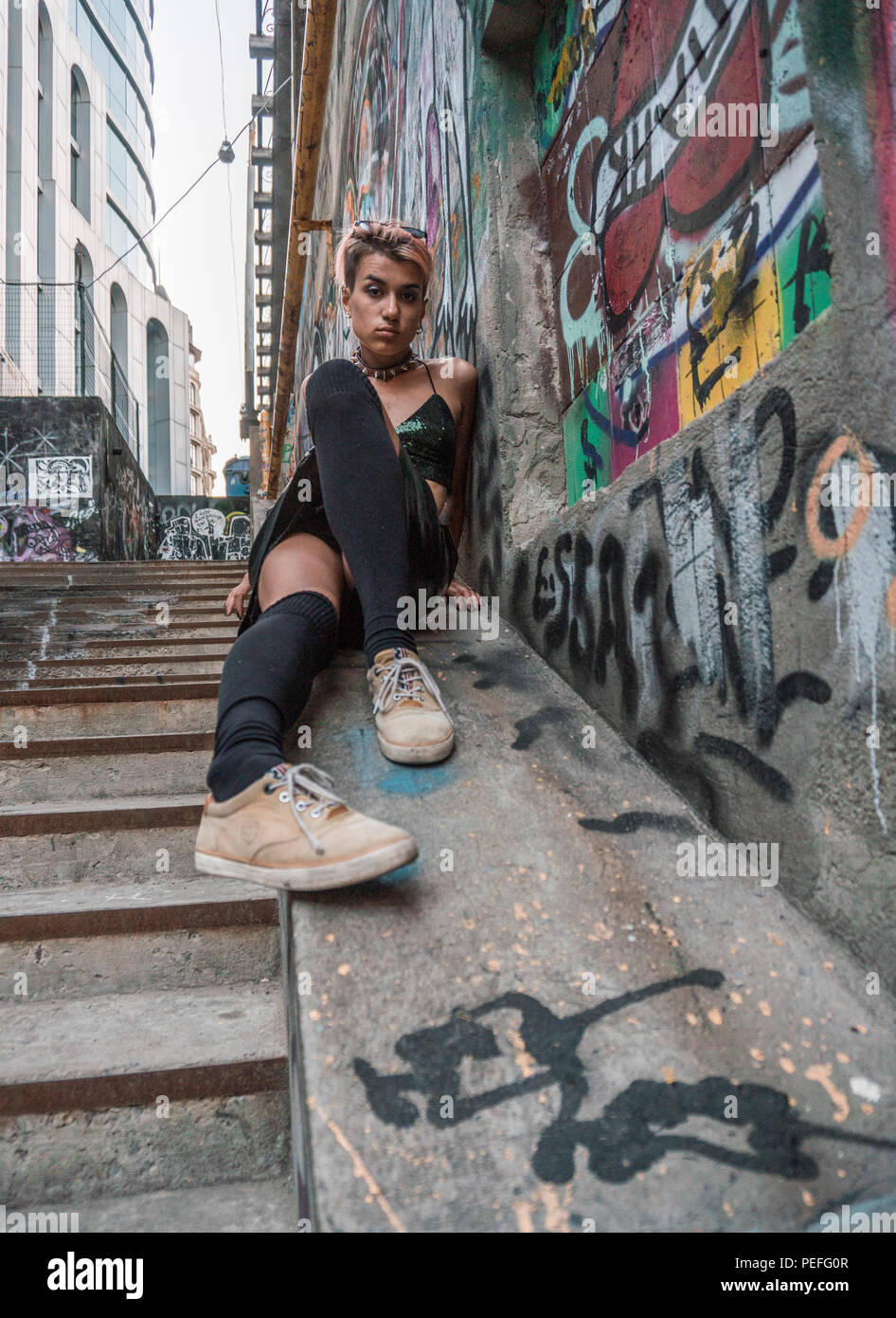 Wide shot of Street punk girl in Urban. Girl Sitting on the Stairs ...
