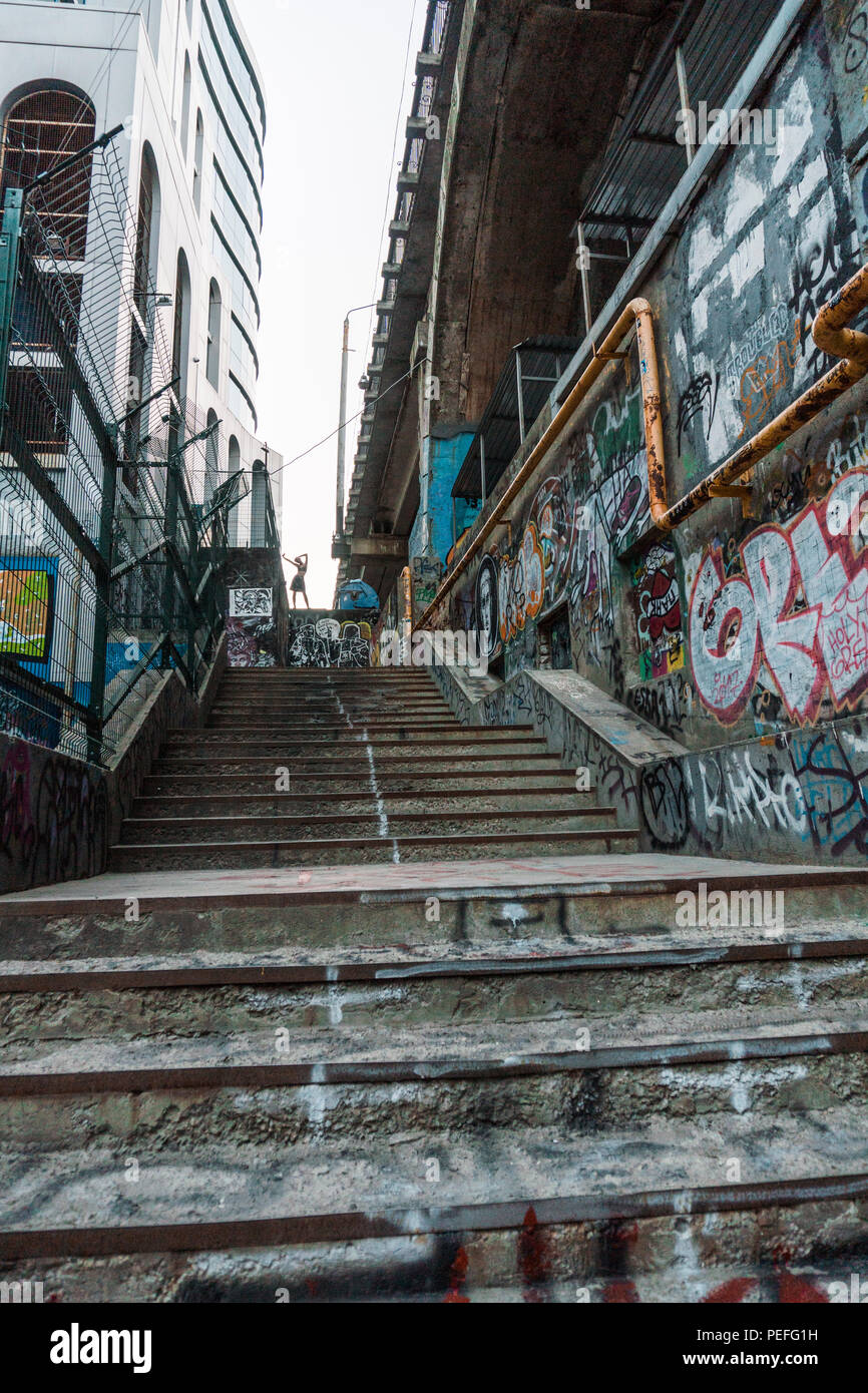 Wide shot of Street punk girl in Urban. Girl stay on the wall painted ...