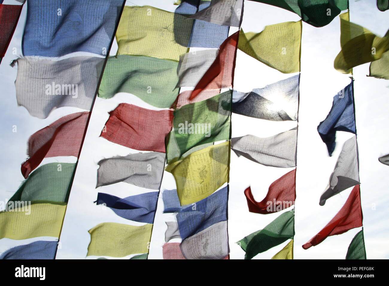 Buddhist Prayer flags backlit by the sun and flapping in the wind Stock ...