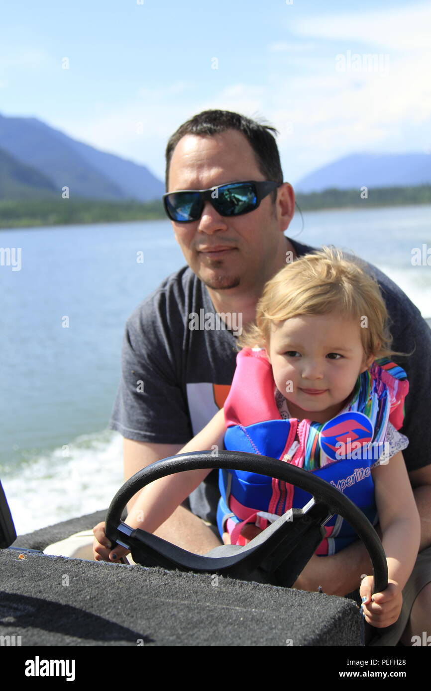 Father and young daughter driving a boat, Noxon, Montana, USA Stock ...