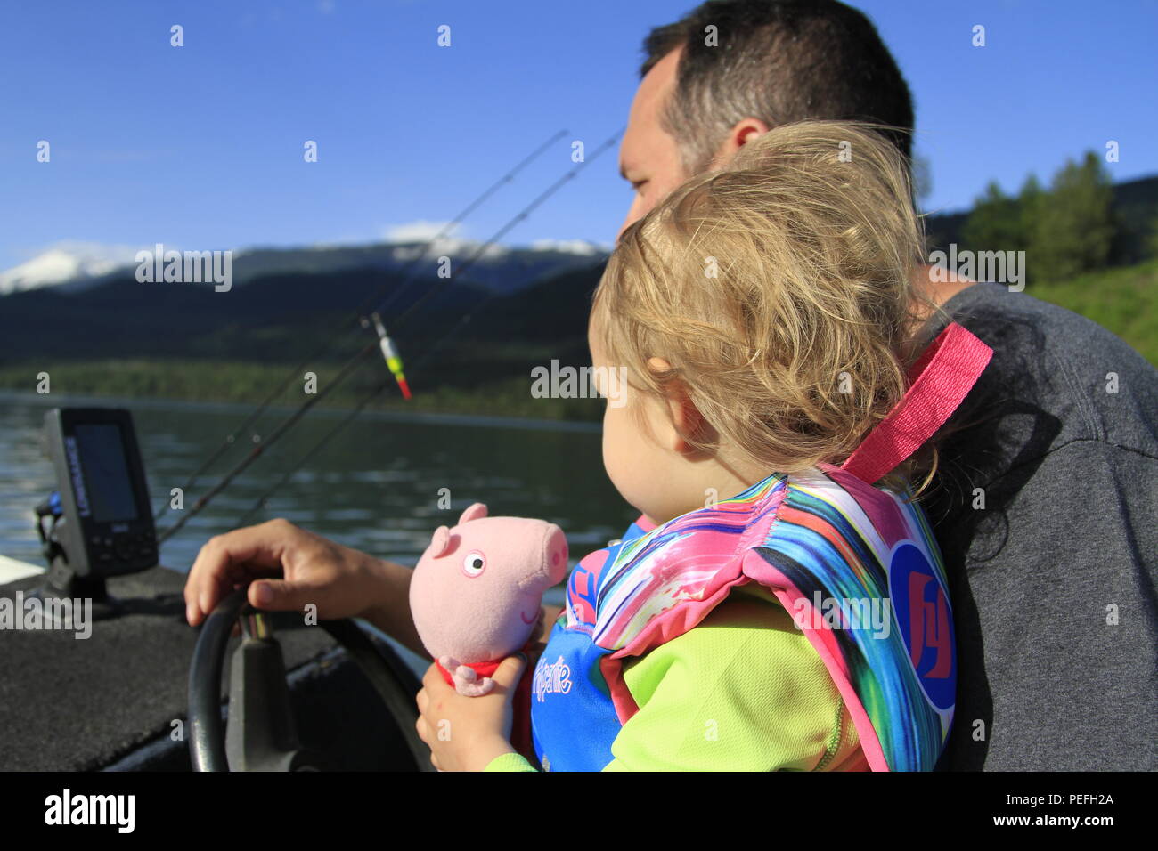 Father and young daughter driving a boat, Noxon, Montana, USA Stock ...