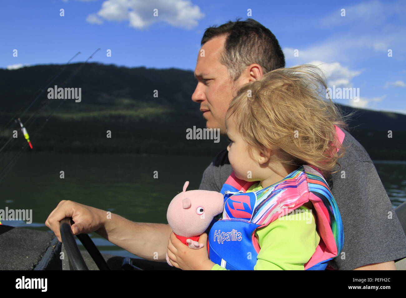 Father and young daughter driving a boat, Noxon, Montana, USA Stock ...