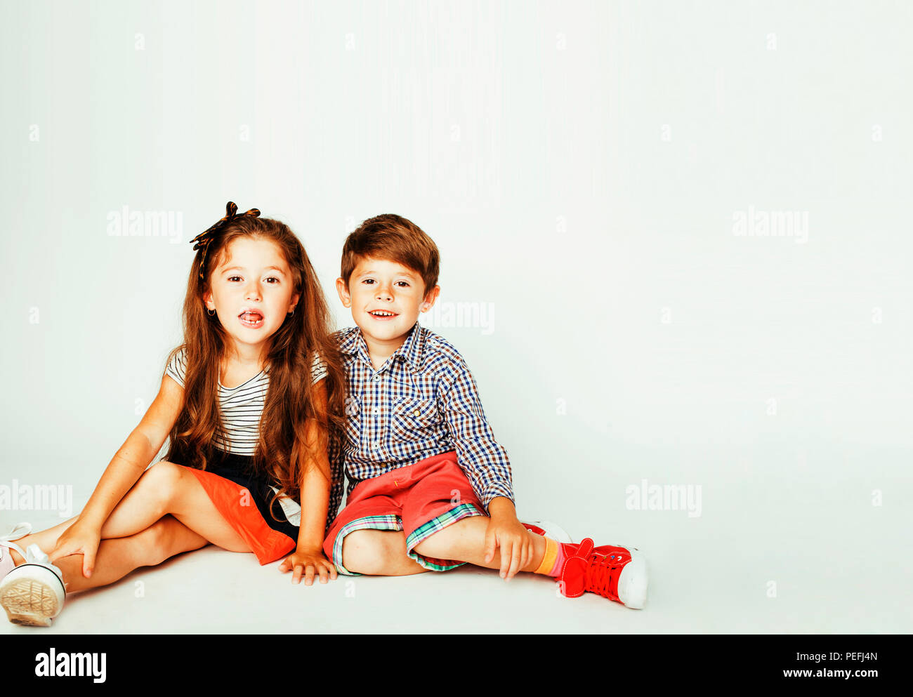 little cute boy and girl hugging playing on white background, ha Stock Photo - Alamy