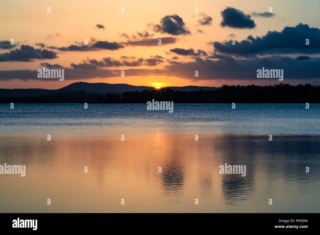 Sun setting over water and rocks hi-res stock photography and images ...