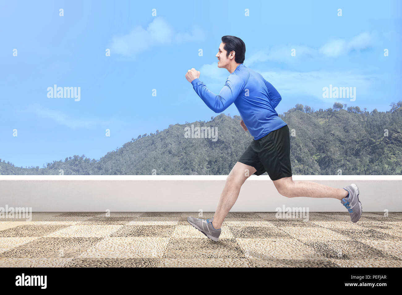 Handsome asian man running outdoors with green hills background Stock ...
