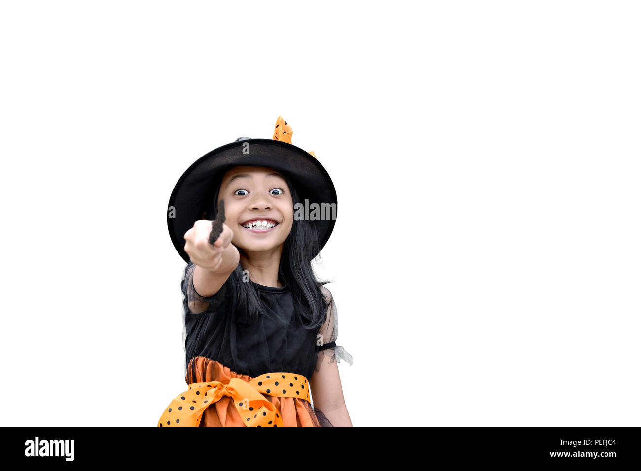 Smiling asian witch girl with magic wand isolated over white background ...