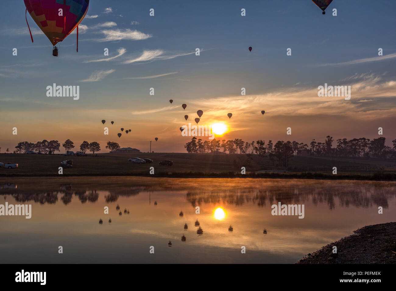 Hot air balloons floating over lake with reflection in water Stock ...