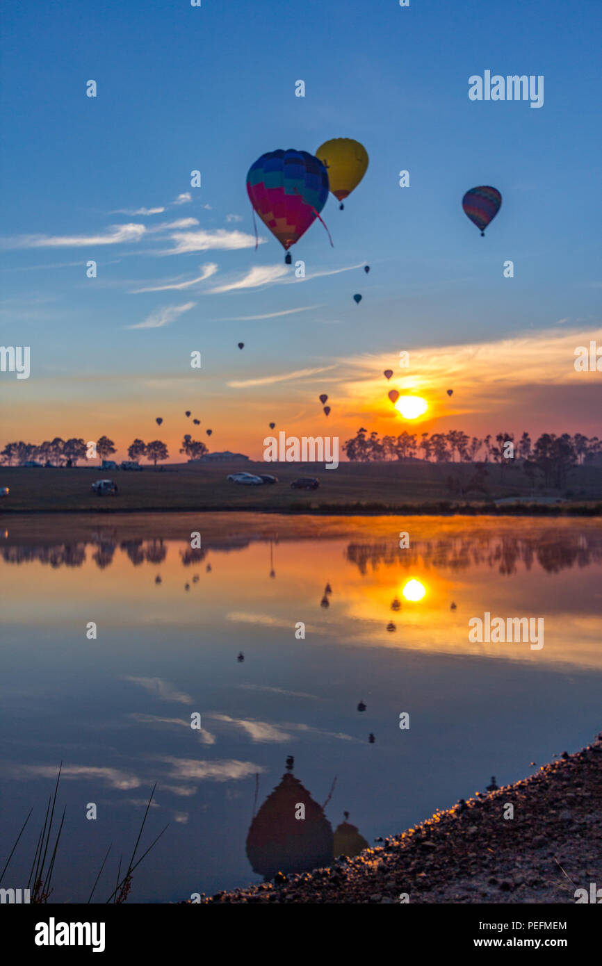 Hot air balloons floating over lake with reflection in water Stock ...