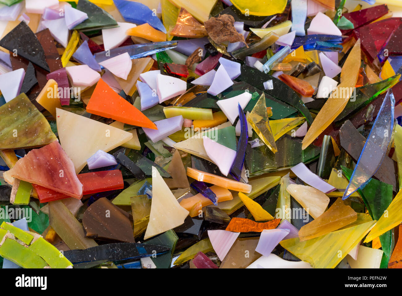 Close-up of bright multicolored stained glass chips in all shapes and ...