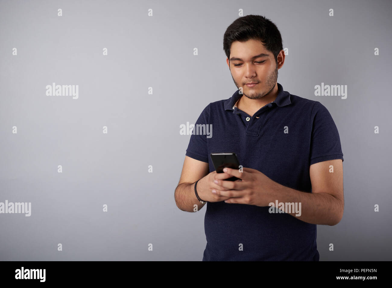 Serious man using smartphone isolated on gray background Stock Photo ...