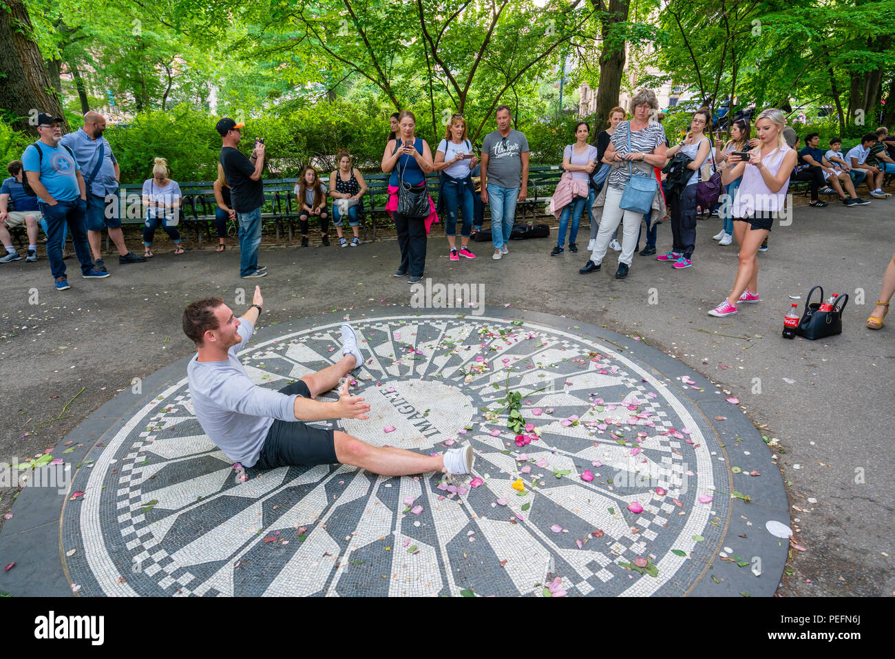 Visitor taking photos with the Imagine memorial mosaic in Central Park ...
