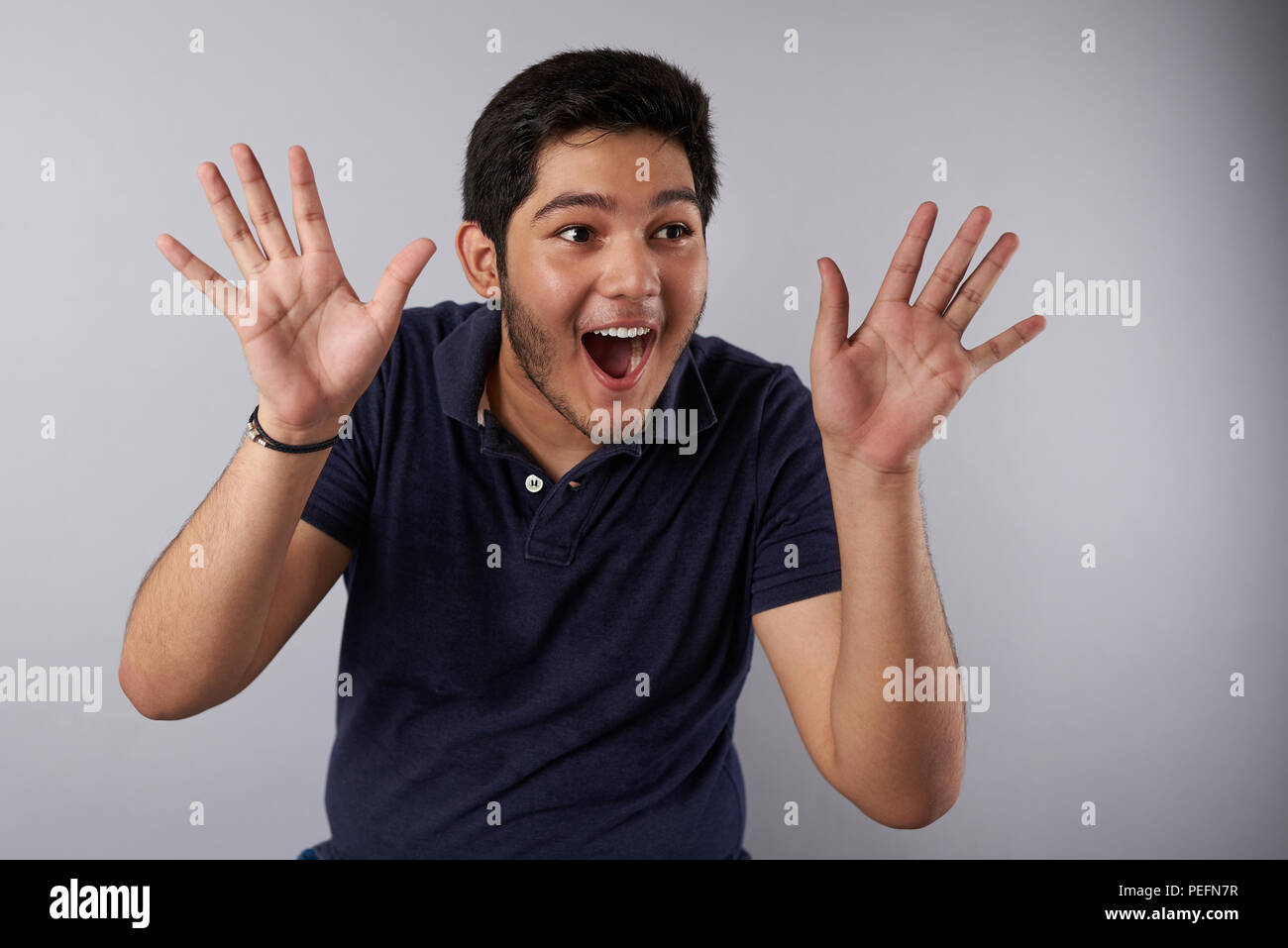 Surprised young man theme in gray studio background Stock Photo - Alamy
