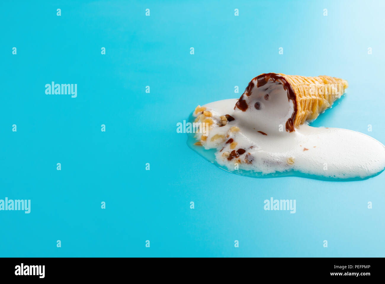 mini Vanilla flavor ice cream cone in a melting process on blue ...