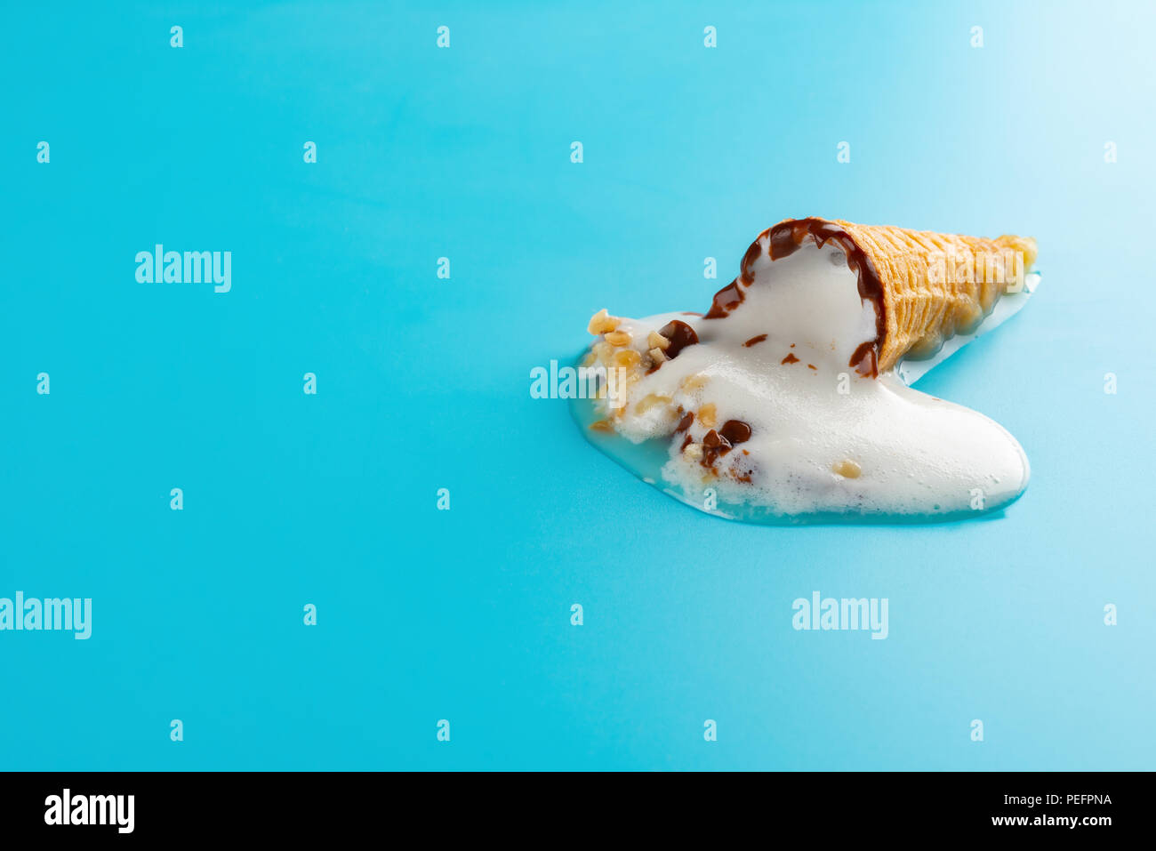 mini Vanilla flavor ice cream cone in a melting process on blue ...