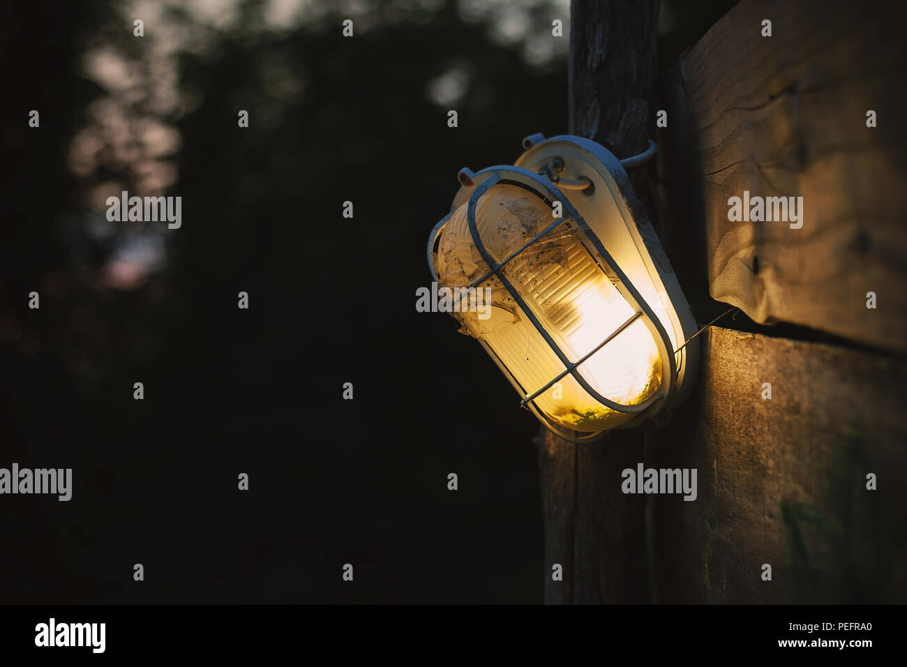 Details of a street broken lamp hanged on wooden board with blurry ...