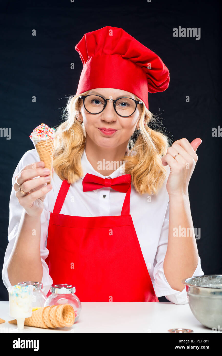 Smiling chef with homemade ice cream, portrait on black background ...