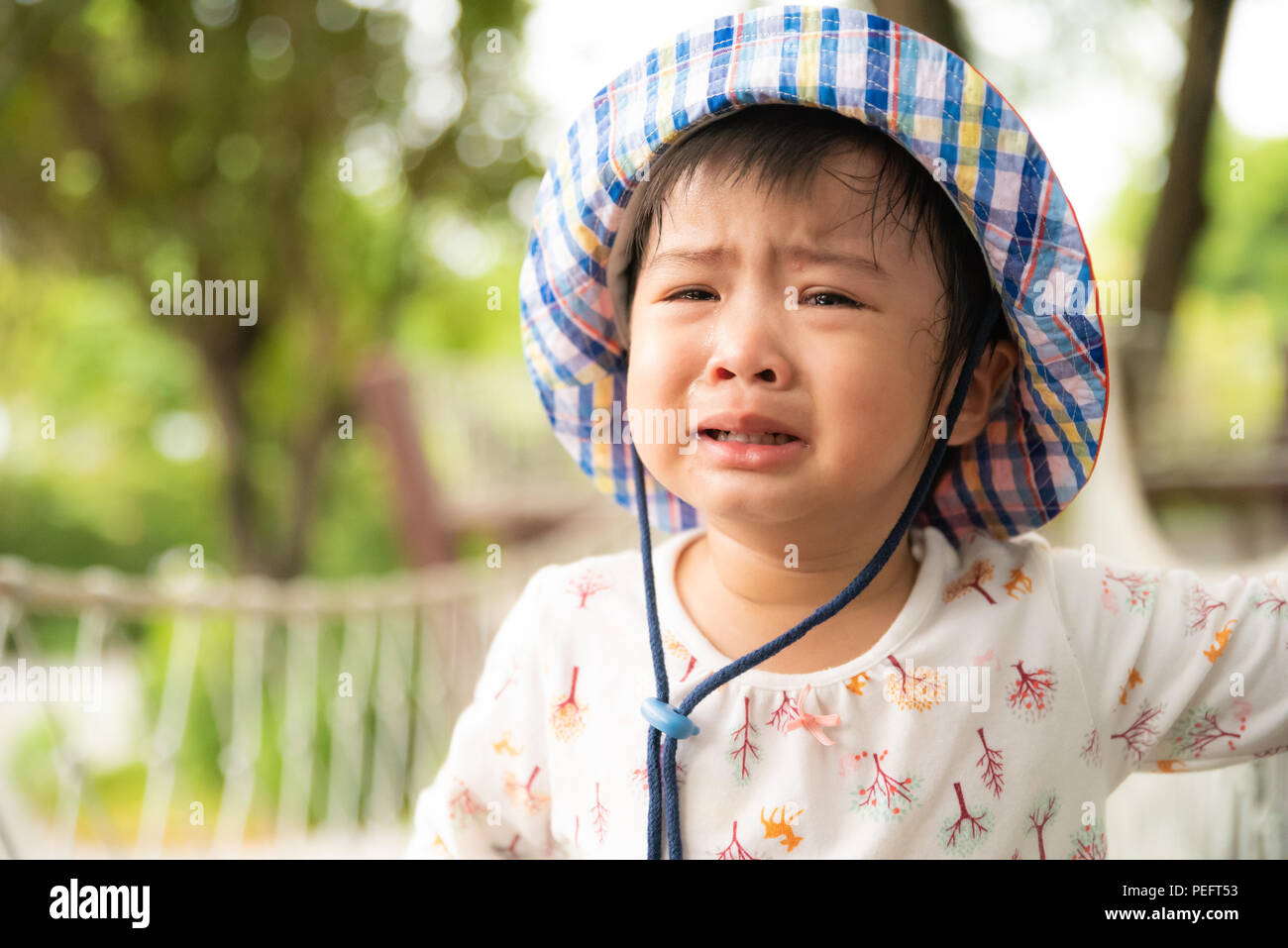 Sad little cute girl crying in the garden Stock Photo - Alamy