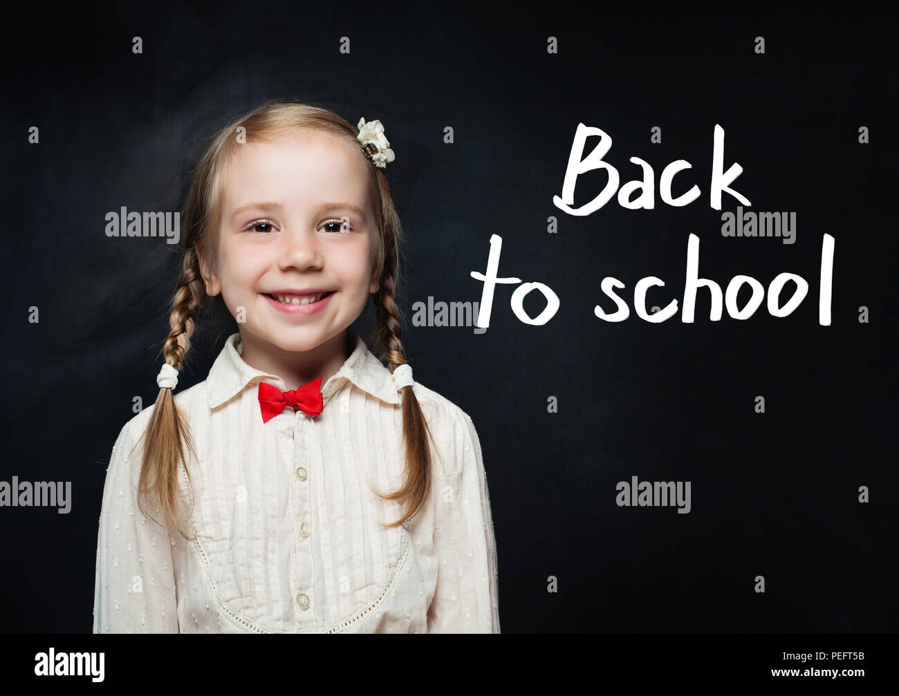 Cute small kid student smiling on blackboard background with back to ...