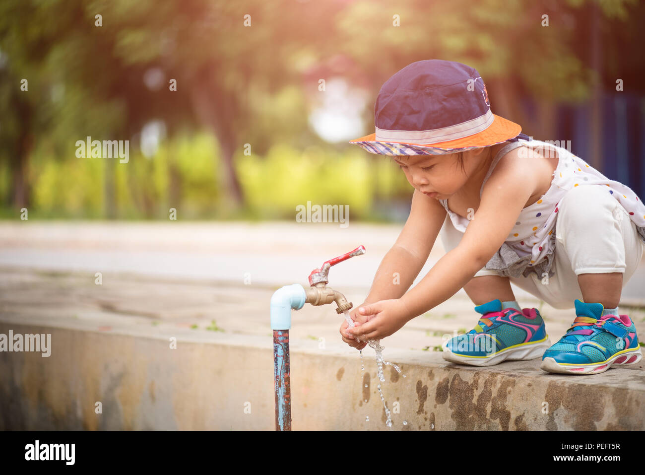 Water pouring in little girl's hands. World Water Day concept Stock ...
