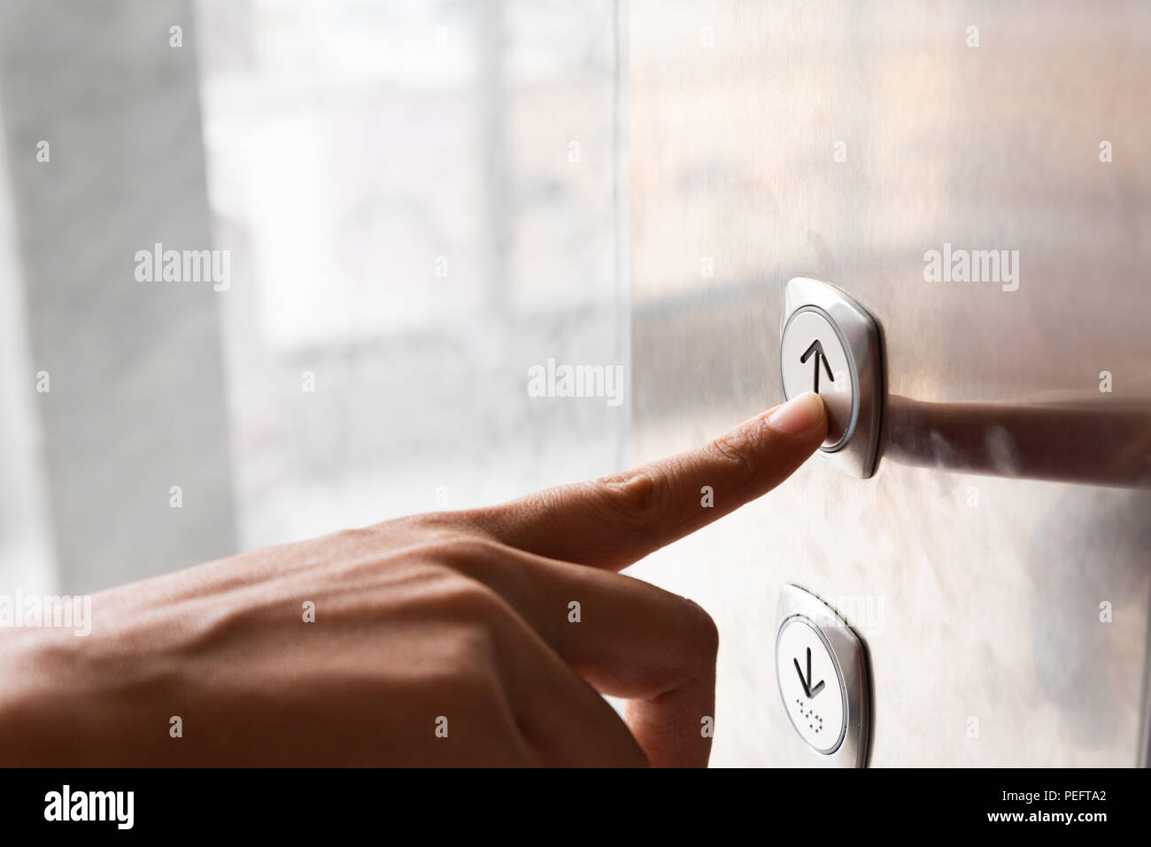 Female person pushing elevator hi-res stock photography and images - Alamy