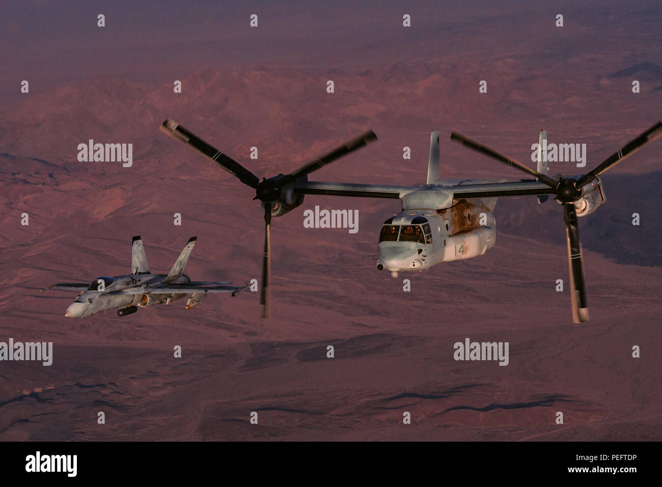 An MV-22 Osprey and a F/A18 Super Hornet with Marine Medium Tilt Rotor Squadron 165 fly in a ...