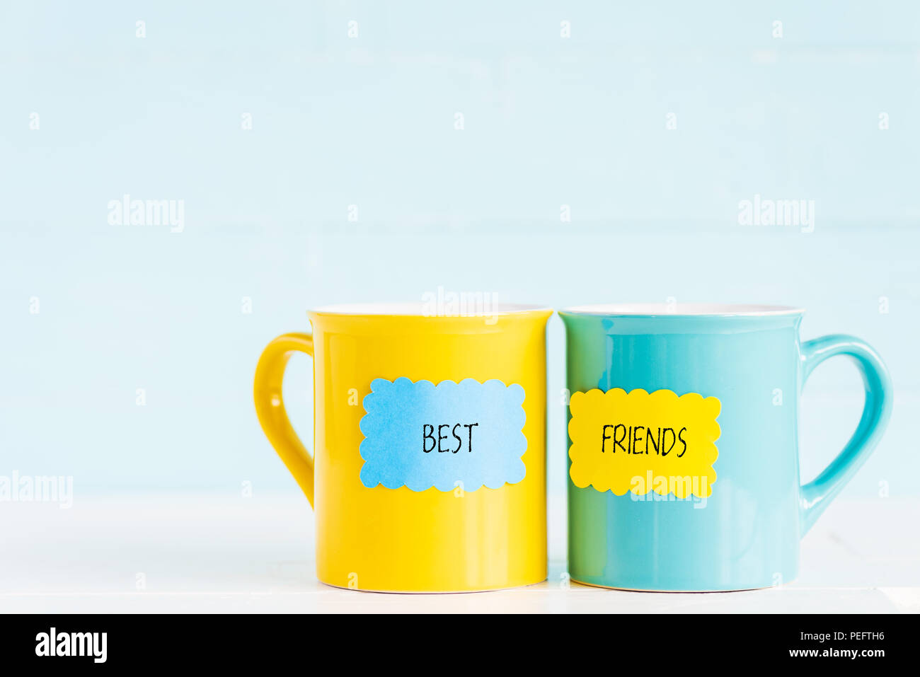 Coffee cups on wooden table with paper tag and best friends text ...