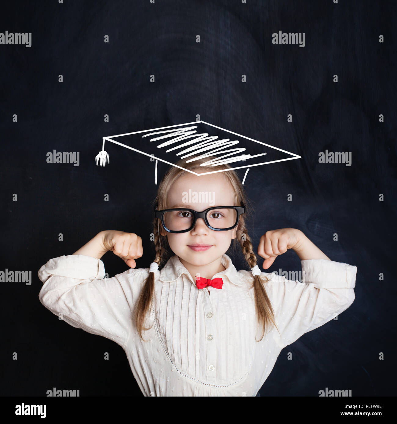 Kid of school age in graduation hat showing his power. School concept ...