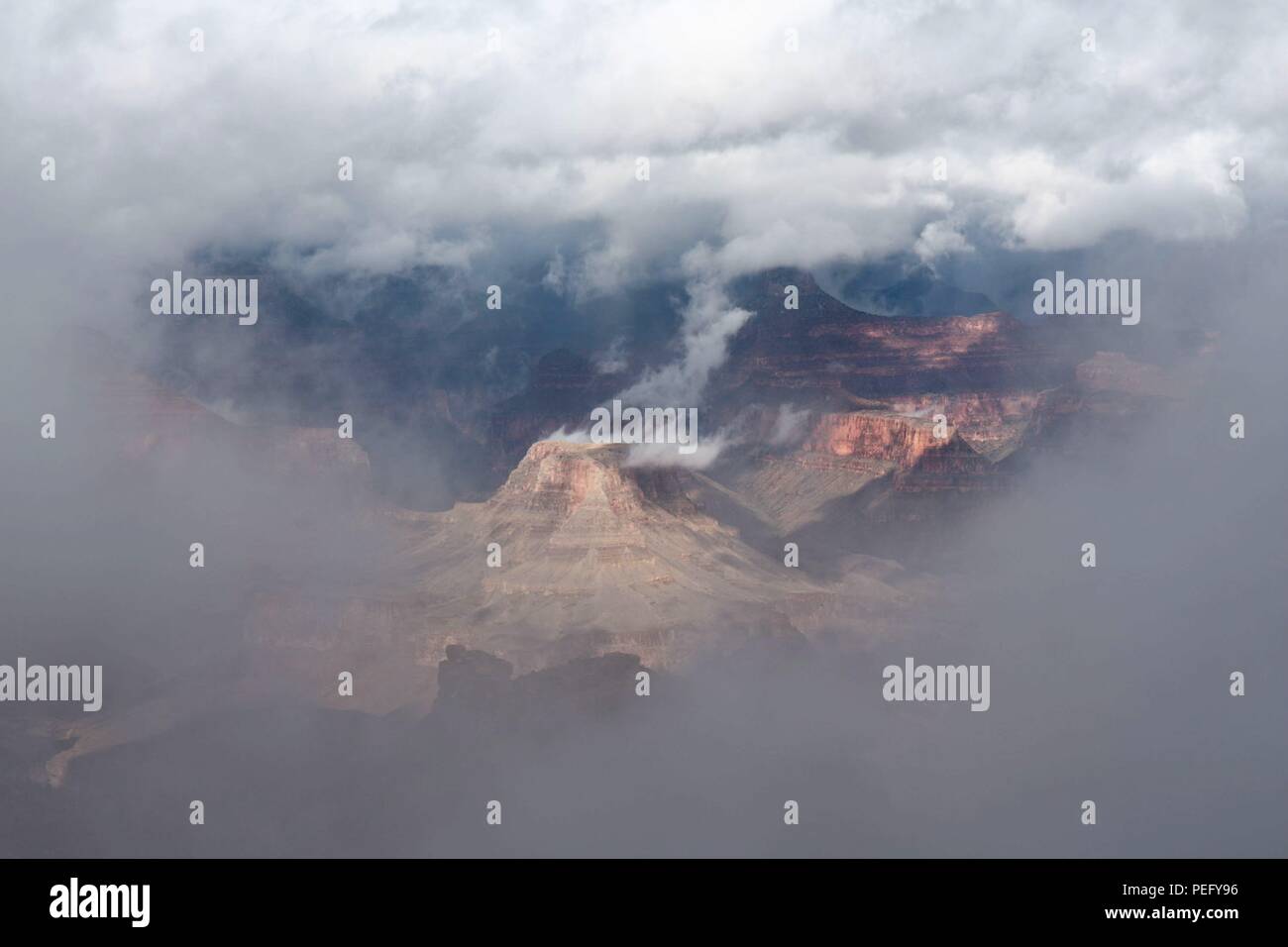 A view of sunny cliffs through dark clouds in grand canyon Stock Photo ...
