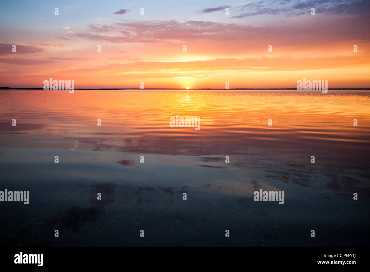 Colorful beautiful cloudy sunset over ocean Stock Photo - Alamy
