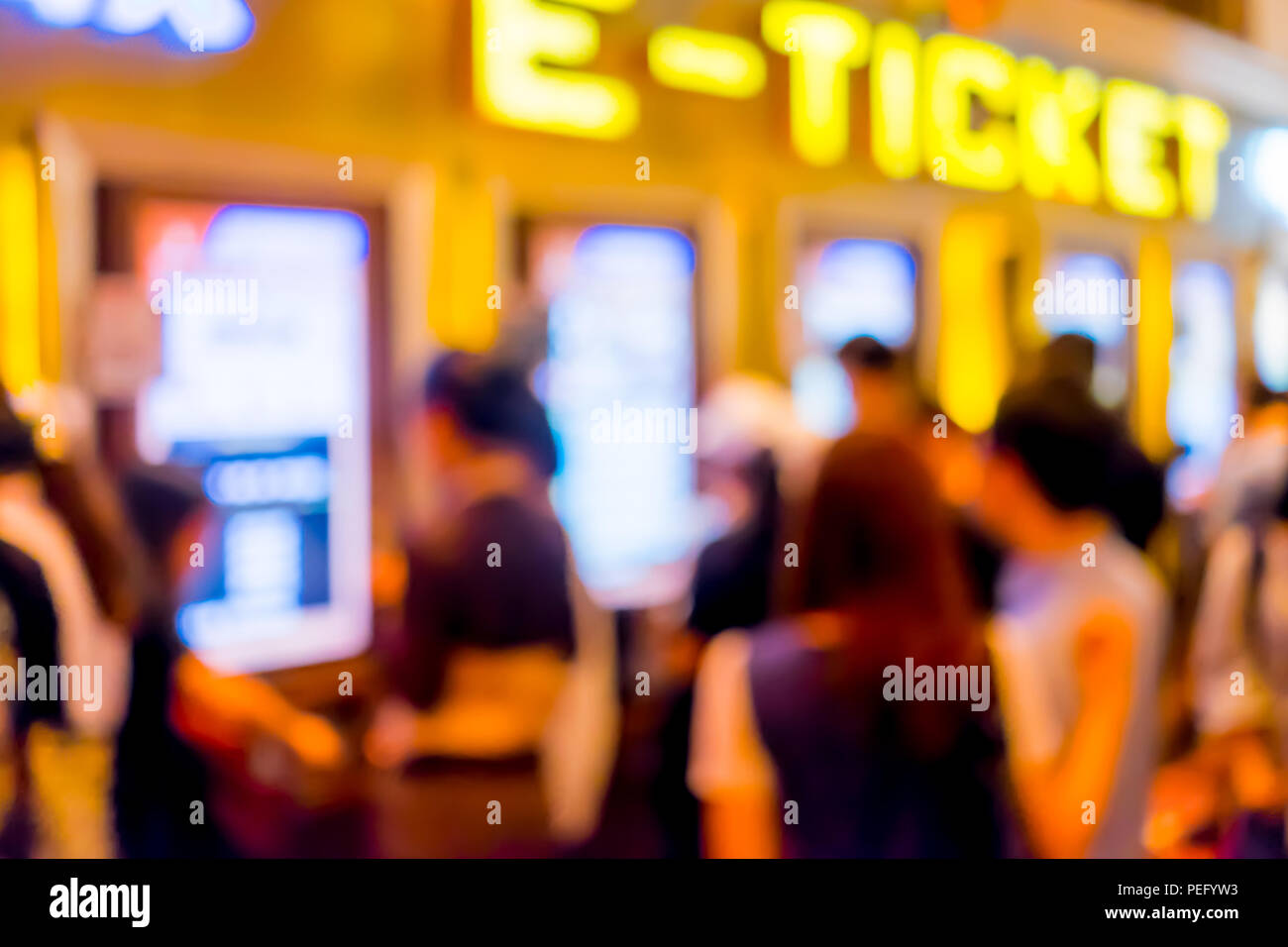 Abstract blur people buying movie ticket from e-ticket selling machine in front of the theater ...