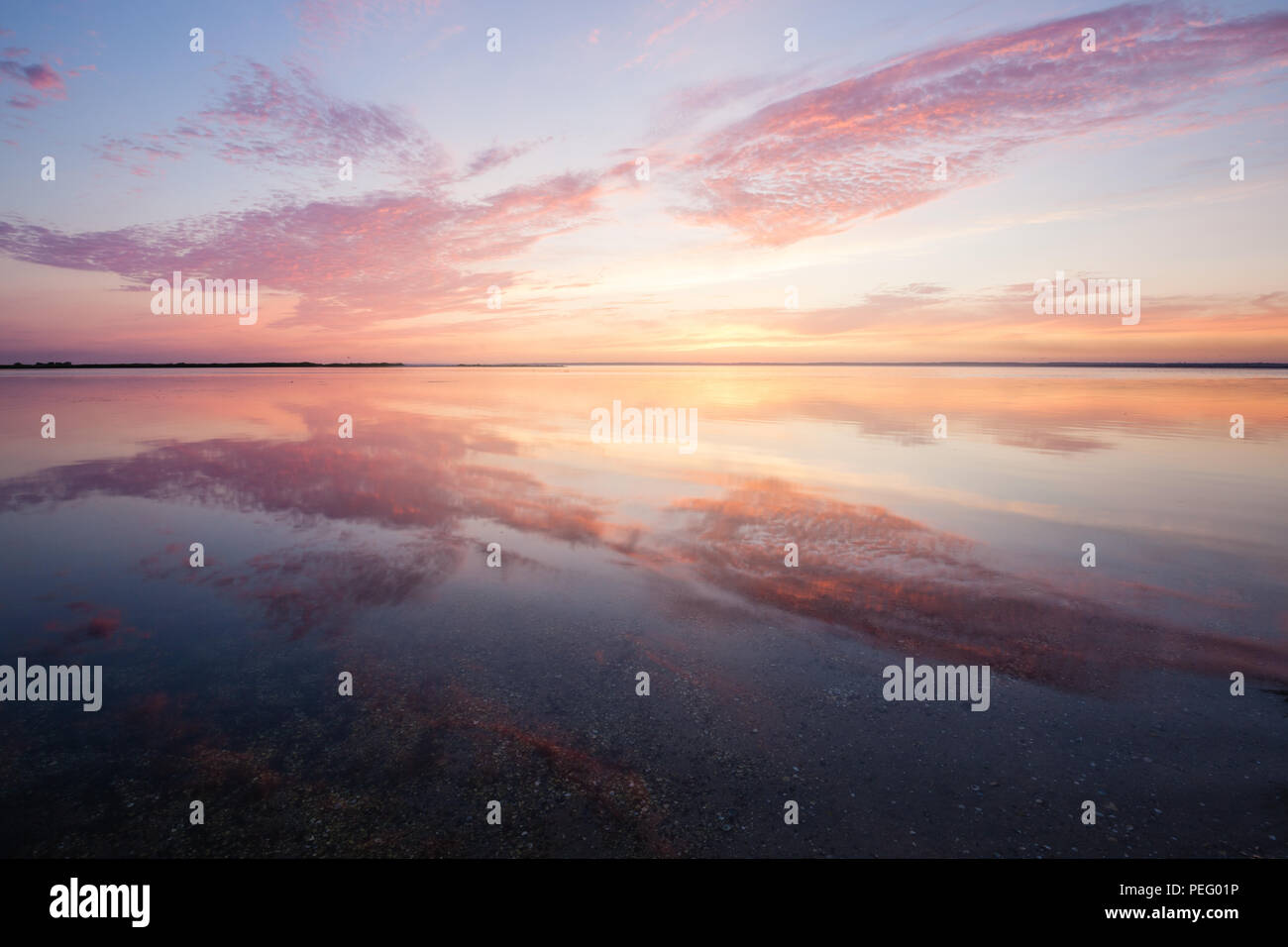 Colorful beautiful cloudy sunset over ocean water surface Stock Photo ...