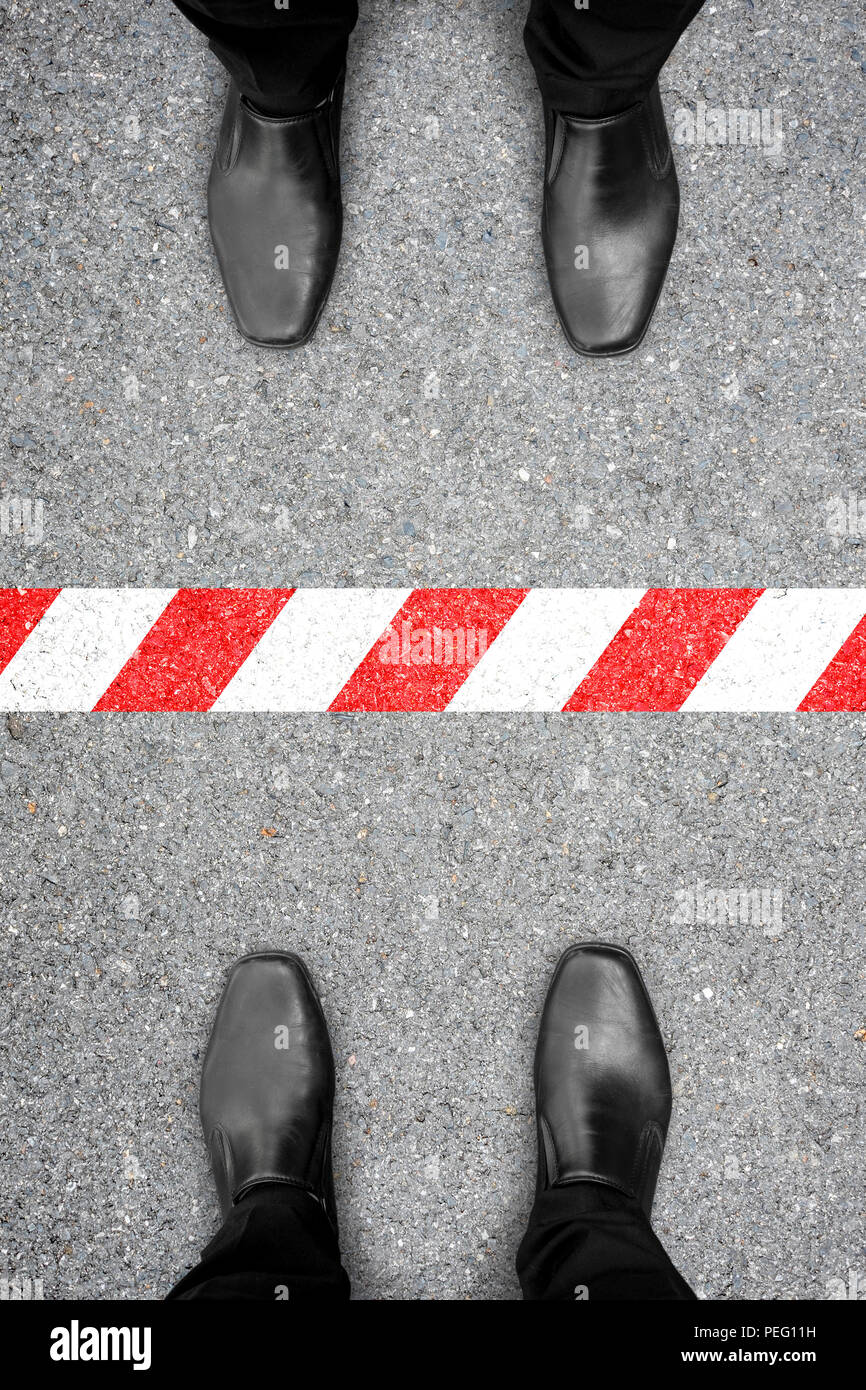 Two men standing in front of red white line in opposite way. Do not ...