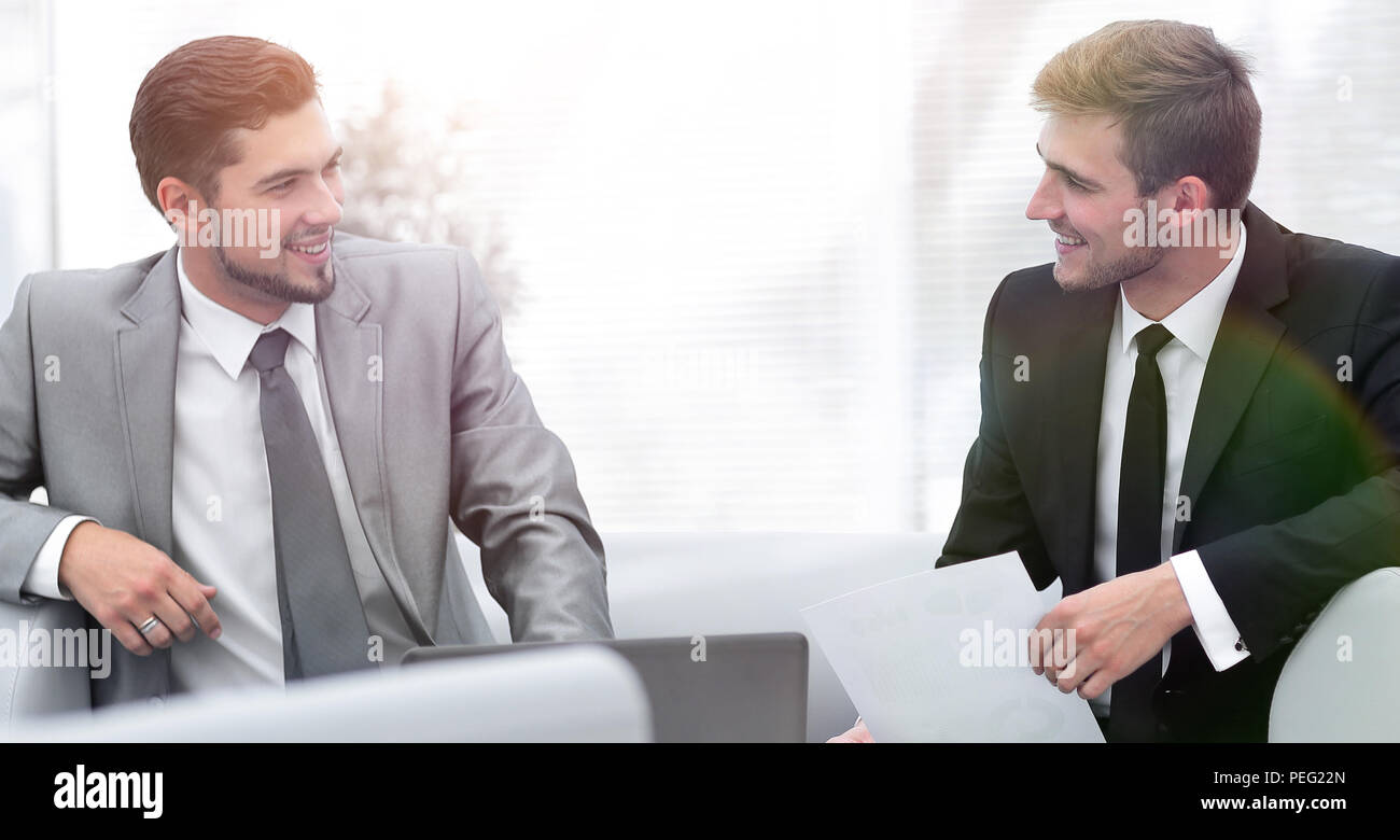 employees talking, sitting the lobby of the office Stock Photo - Alamy