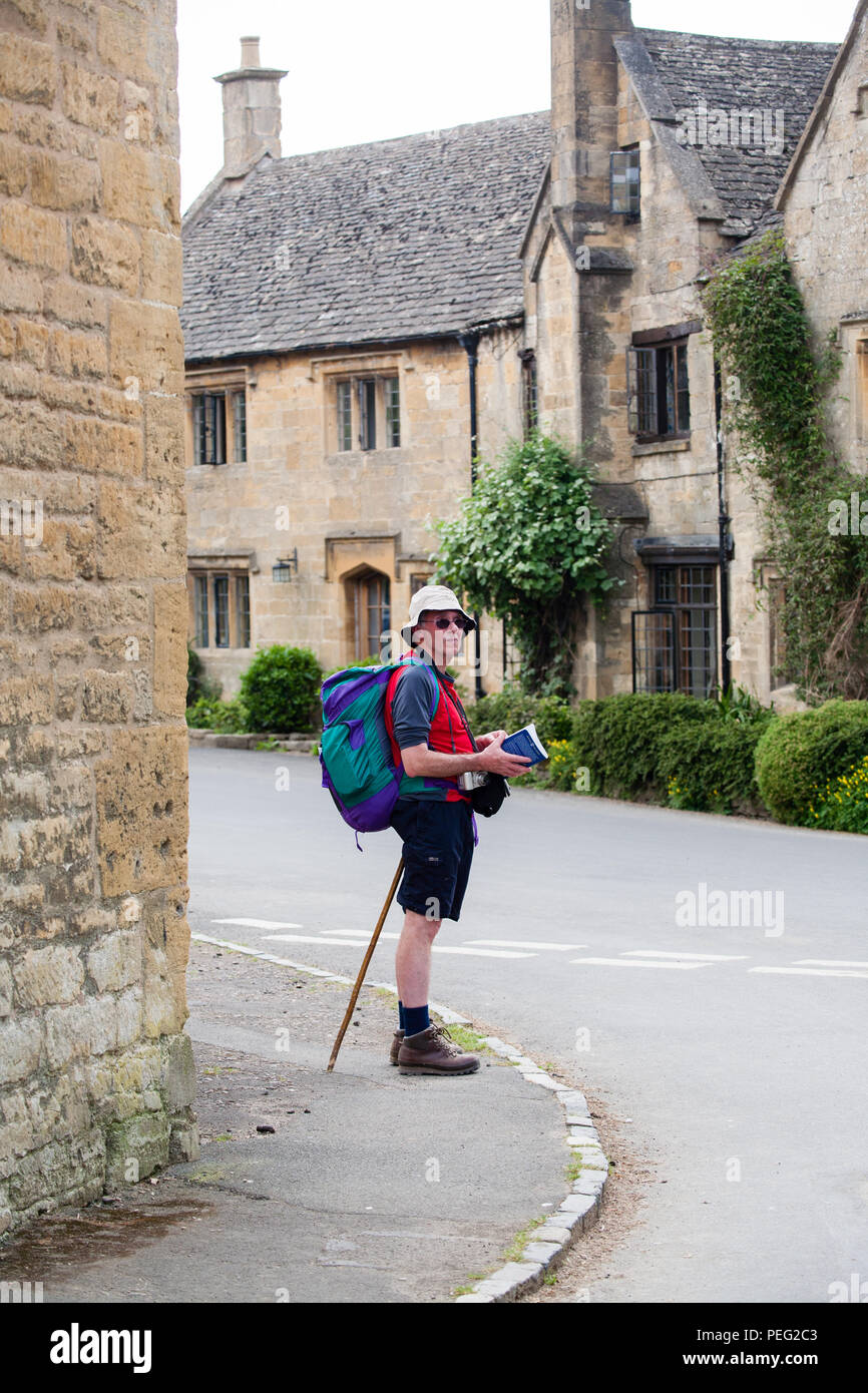Hiker checking directions in Stanton village with honey coloured ...