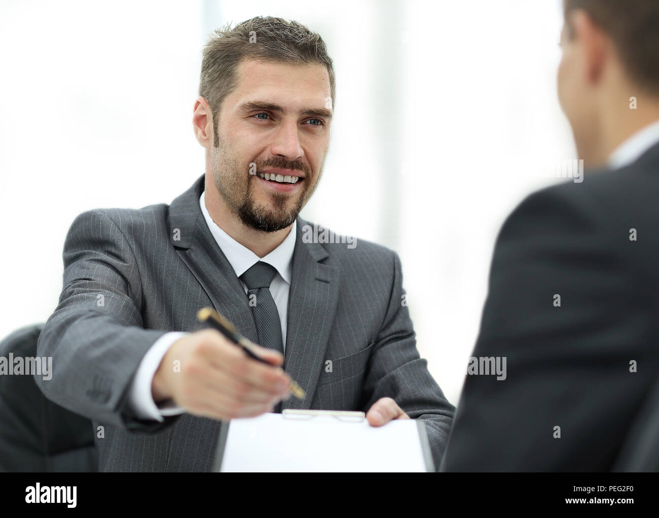 closeup.smiling businessman signing a lucrative contract.the business ...
