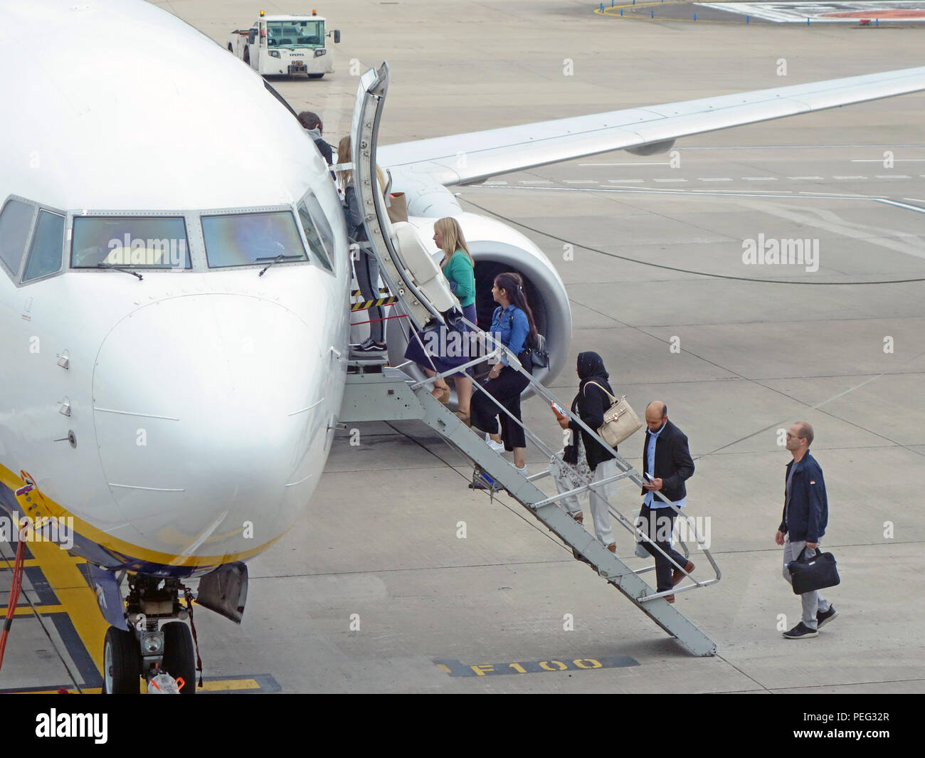 Close up of plane cockpit window and steps as passengers climbing steps ...