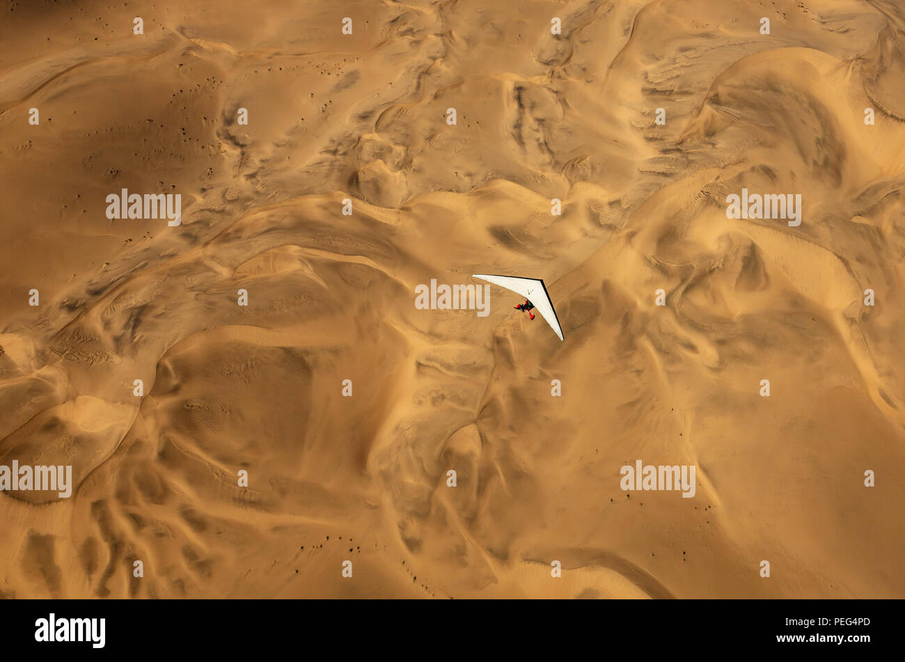An ultralight aircraft can be seen flying over the sands of Namibia ...