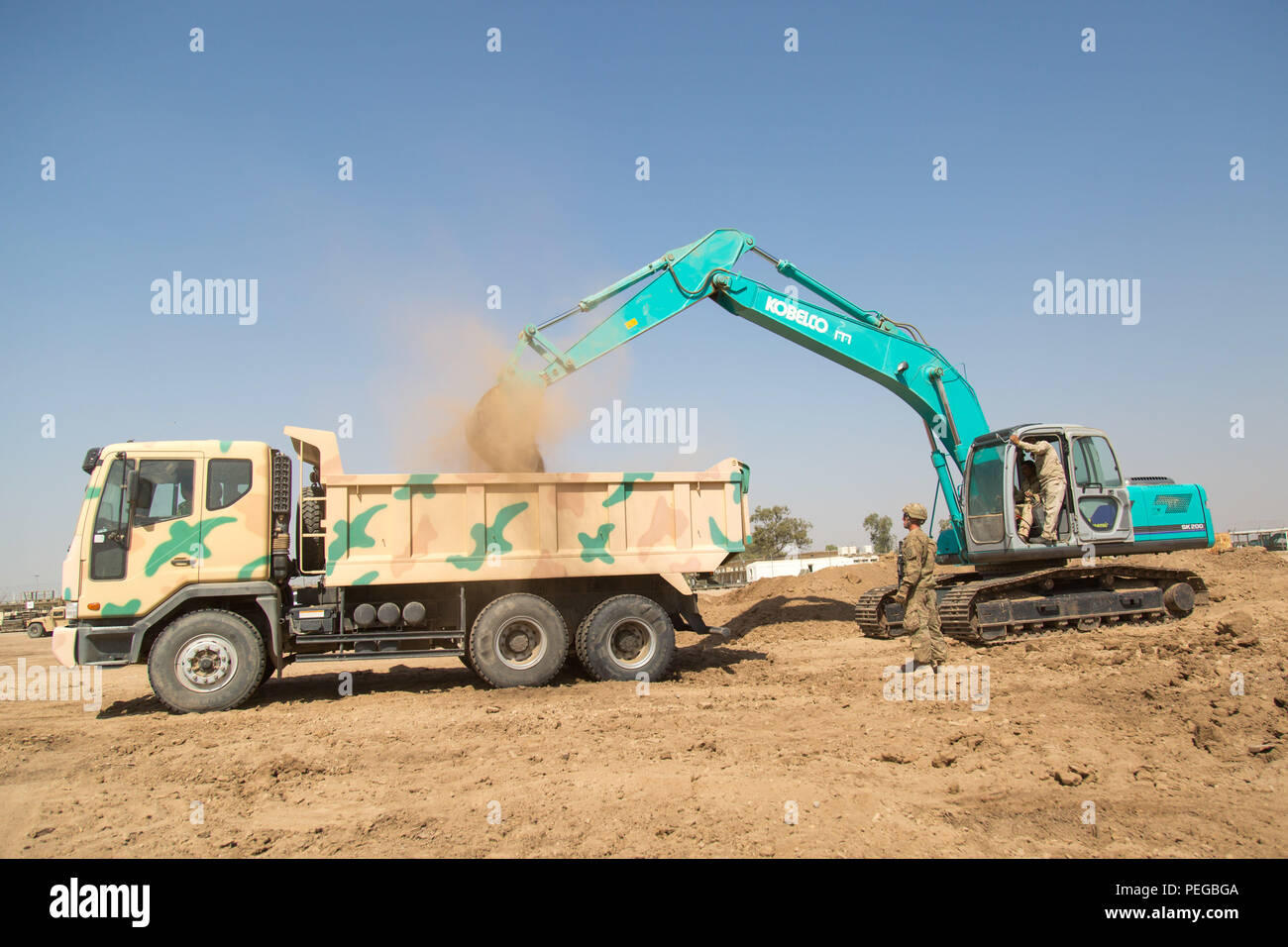 Iraqi army engineers learn to use a hydraulic excavator to fill a dump ...